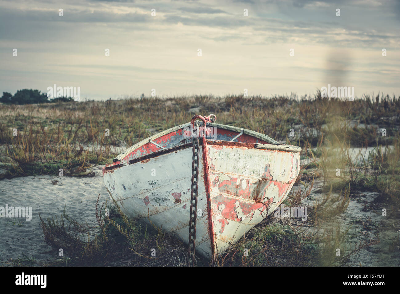 Shipped small boat sitting on the beach at sunset. Old and weathered ...
