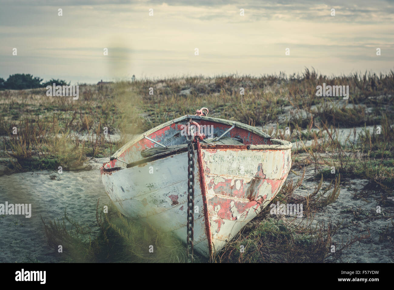 Shipped small boat sitting on the beach at sunset. Old and weathered ...