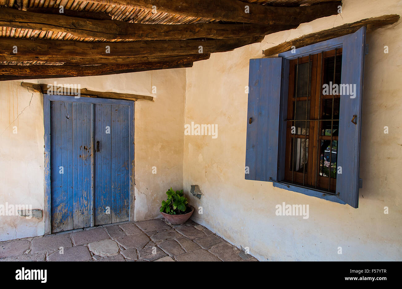 Veranda of an old traditional Cypriot house with blue wooden door and ...