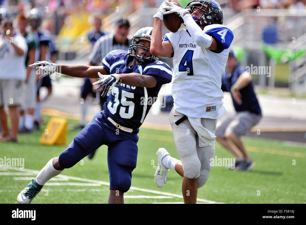 A high school wide out takes in a touchdown pass in full stride behind ...