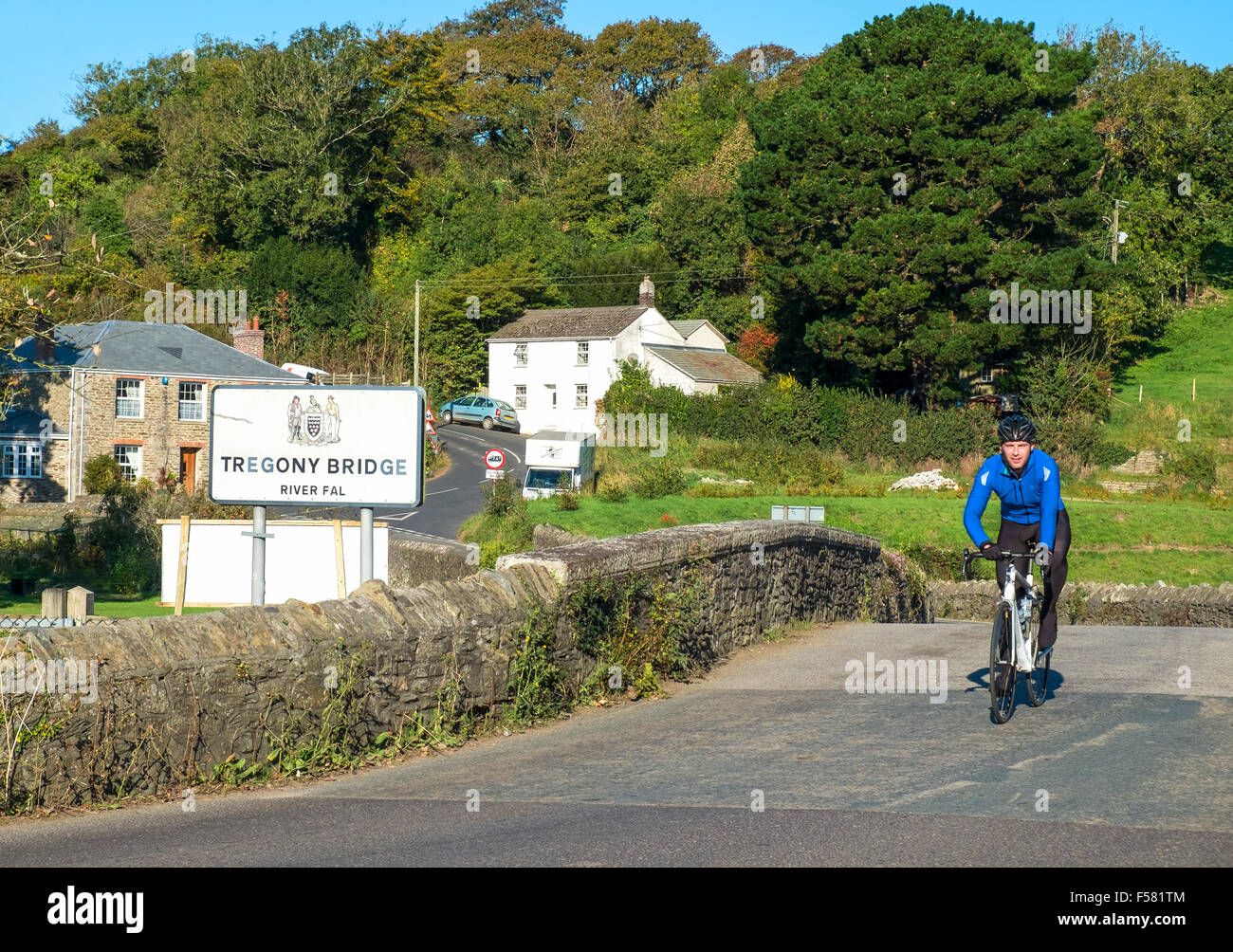 A cyclist riding through the village of Tregony in Cornwall, UK Stock ...