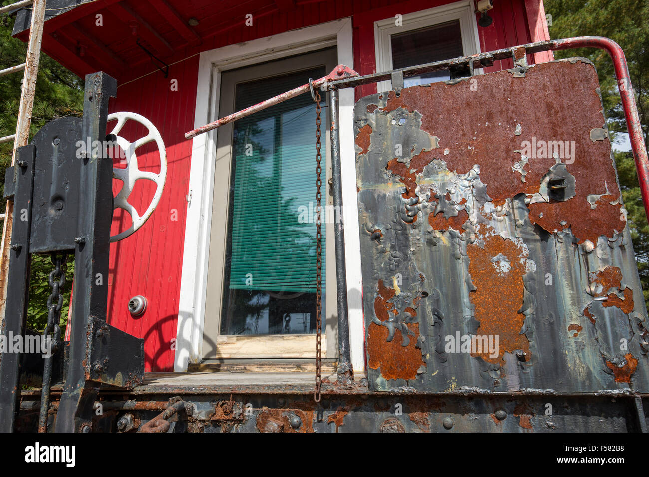 Front of red caboose, with steel plate that has peeling black paint and ...