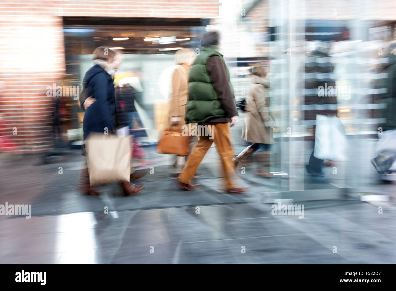 Group of people walking in shopping centre, zoom effect, motion blur ...