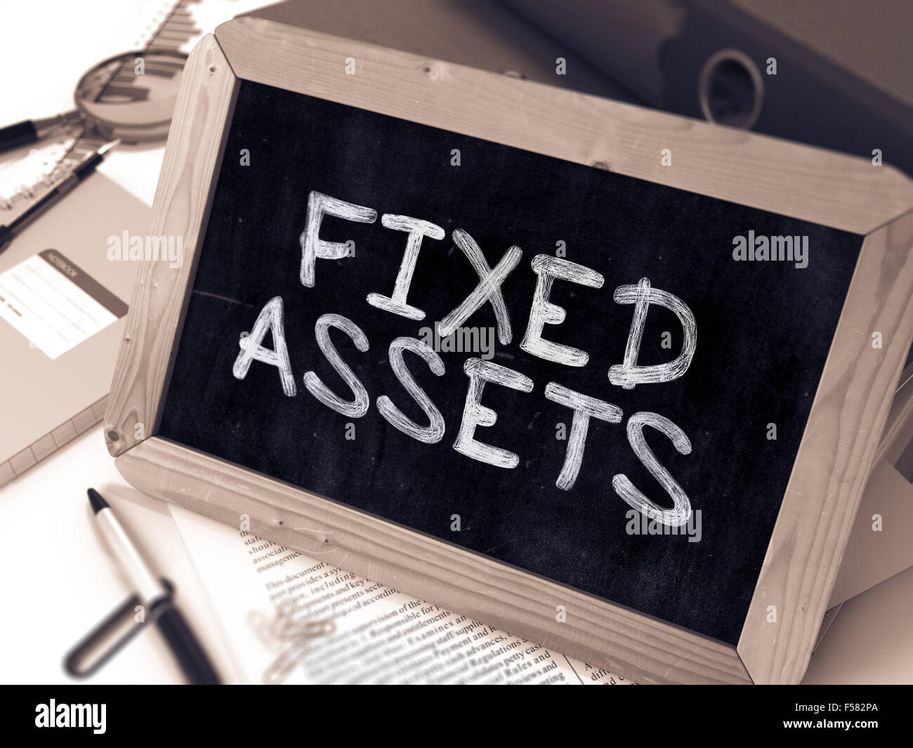 Fixed Assets Handwritten on Chalkboard. Composition with Small ...