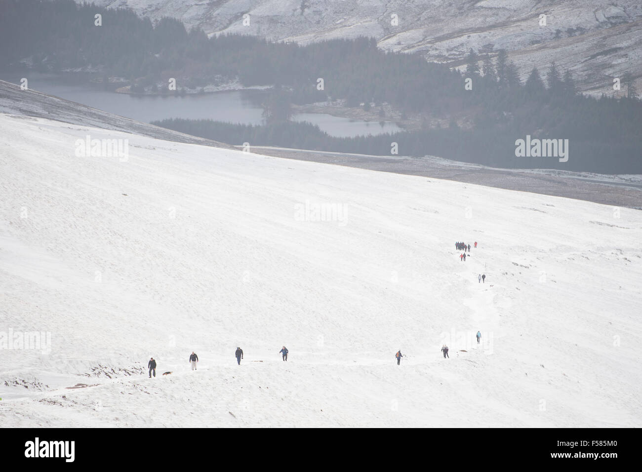 Walkers walk through heavy deep snow at Pen y Fan mountain, Brecon ...