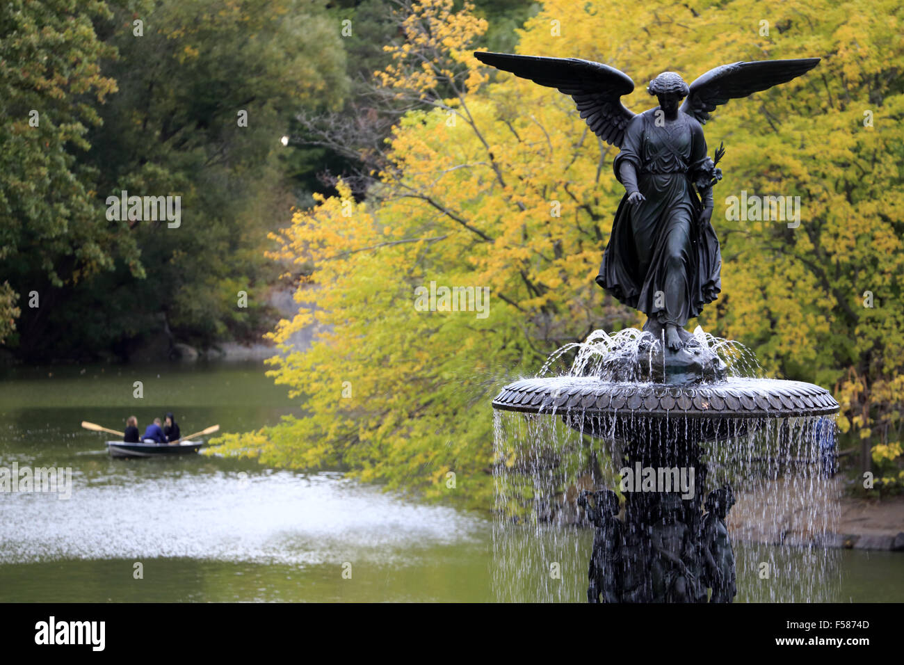Winged angel of Bethesda Fountain with visitors boating in the Lake in ...