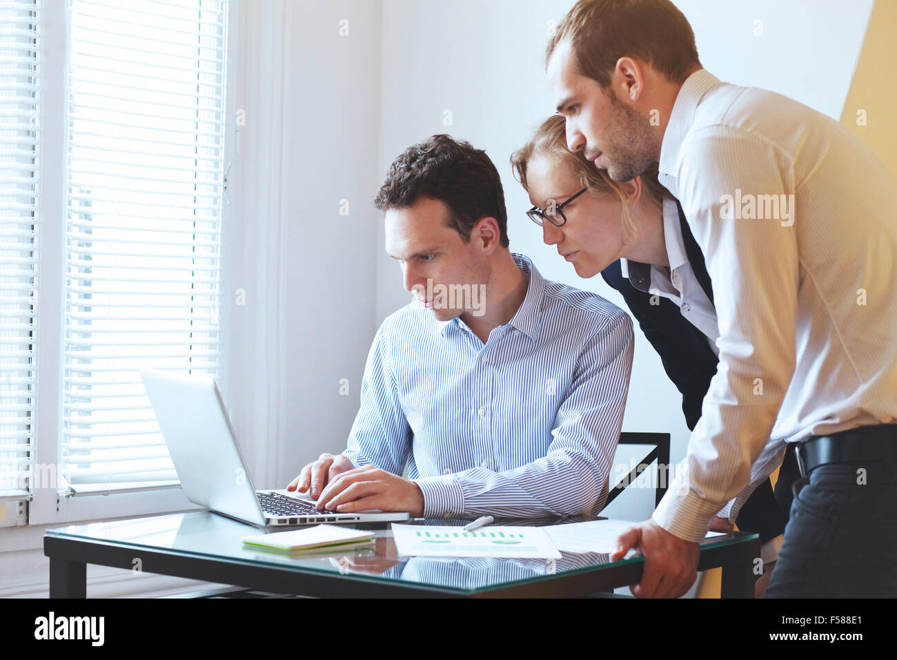 group of young business people looking at the screen of computer Stock ...