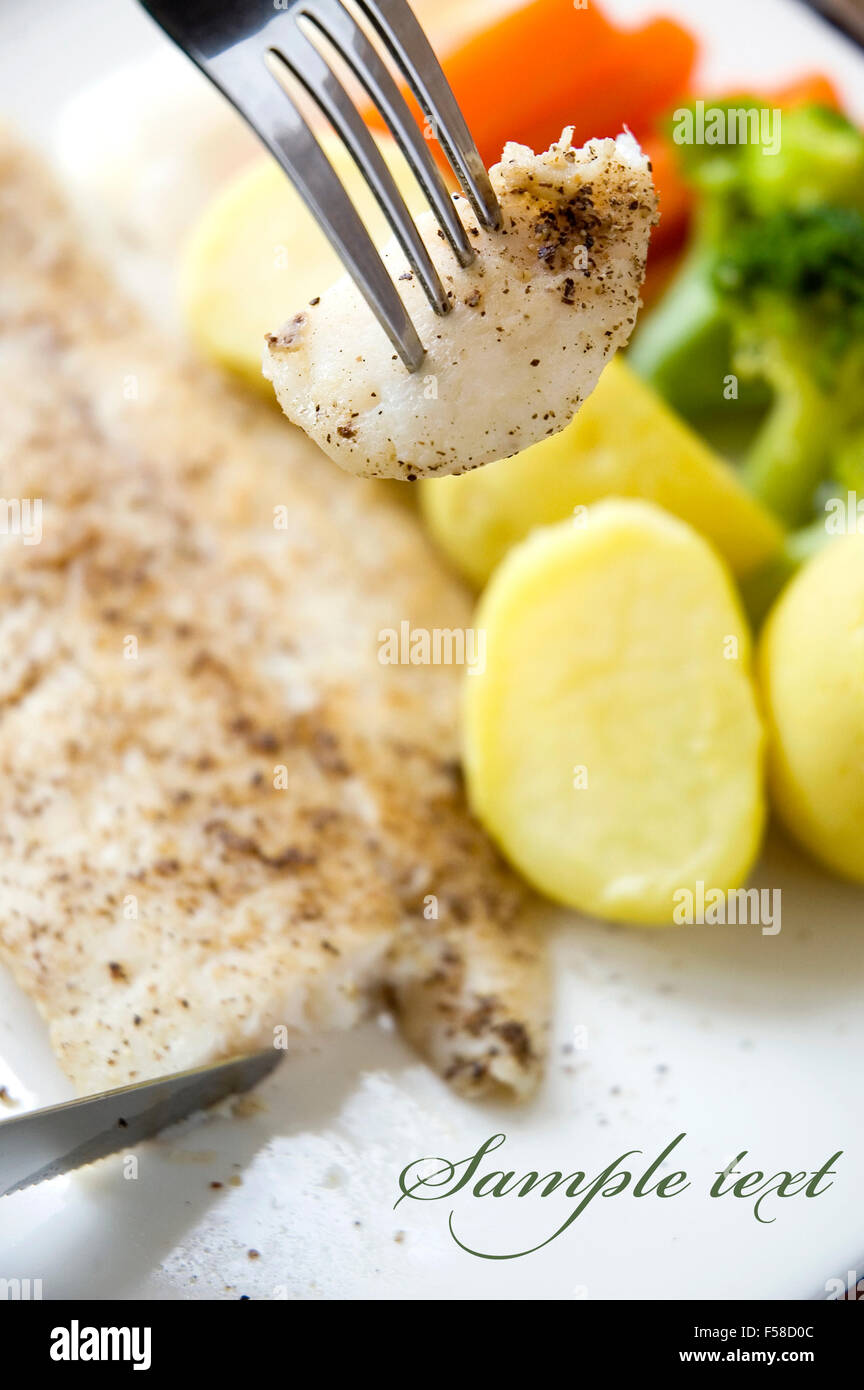 a piece of fish on fork and healthy dish background with sample text ...