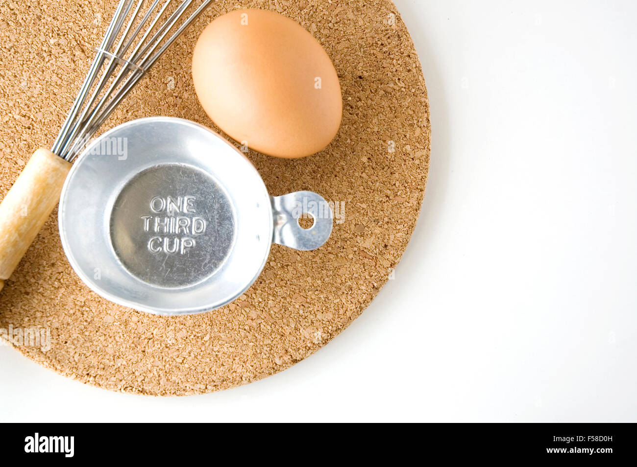 measuring one third cup with egg and whisk on board Stock Photo - Alamy