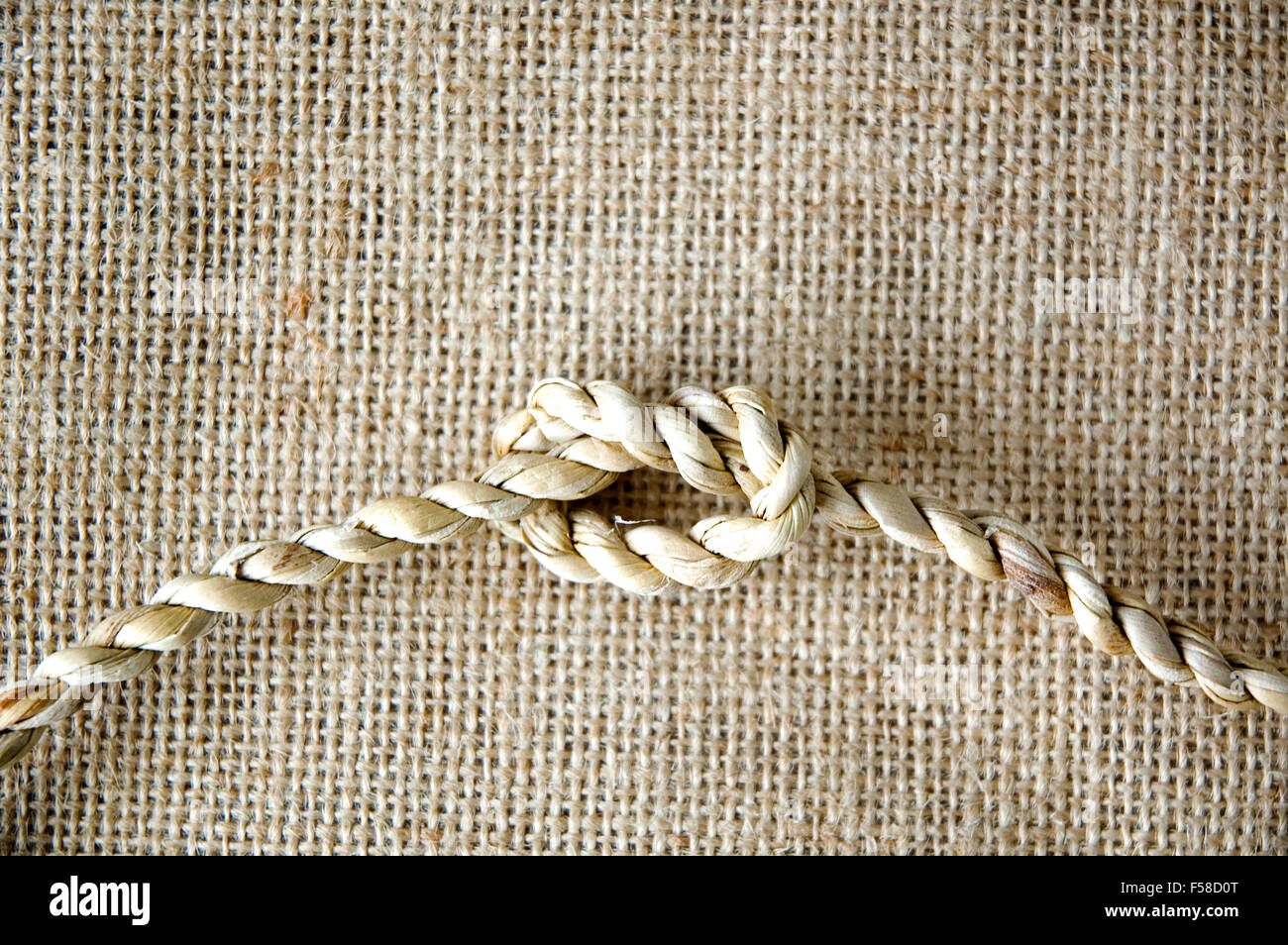 natural rope knot on sackcloth background Stock Photo - Alamy