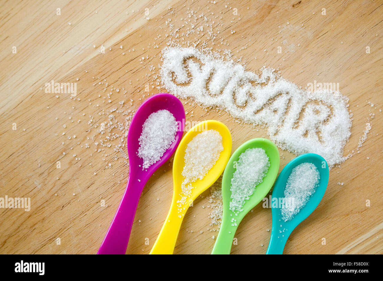 sugar wording on wooden table with colorful spoon Stock Photo - Alamy