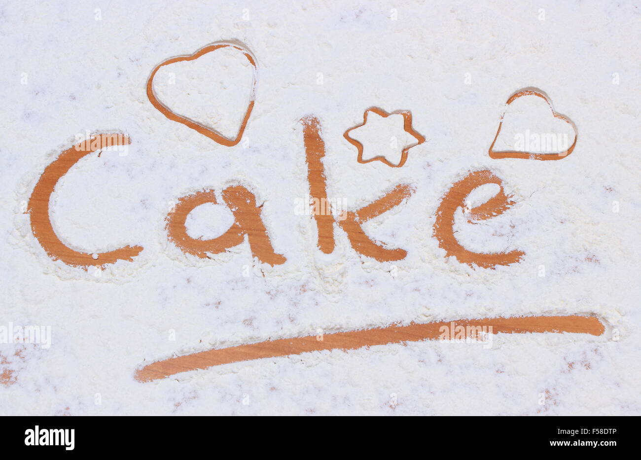 Word cake and heart shape written in white flour, concept of baking ...