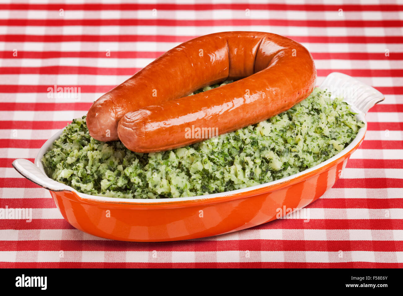 A dish with 'Boerenkool met worst' or kale with smoked sausage; a ...
