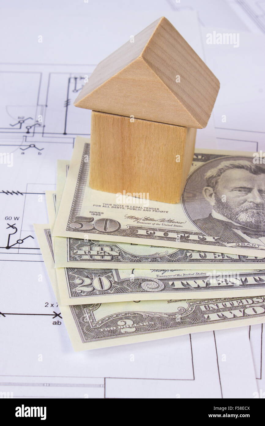 House shape made of wooden blocks and currencies dollar lying on ...