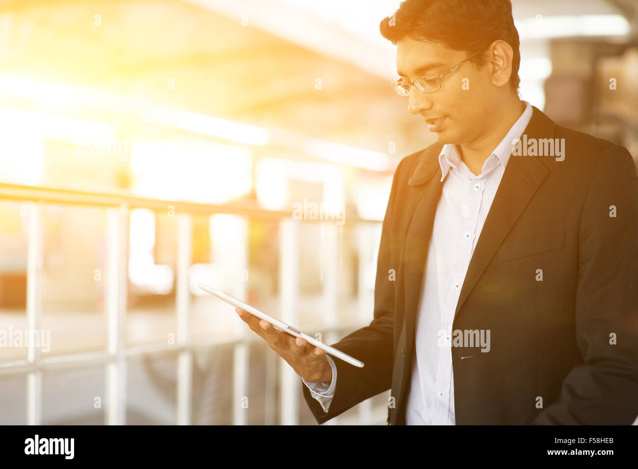 Indian business man using tablet computer while waiting train at ...
