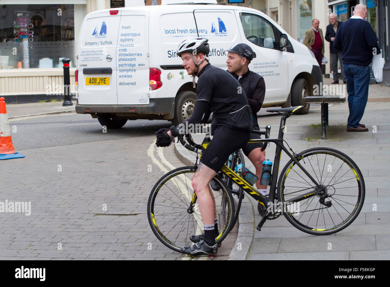 Two sporting cyclists by a pavement/sidewalk Stock Photo - Alamy