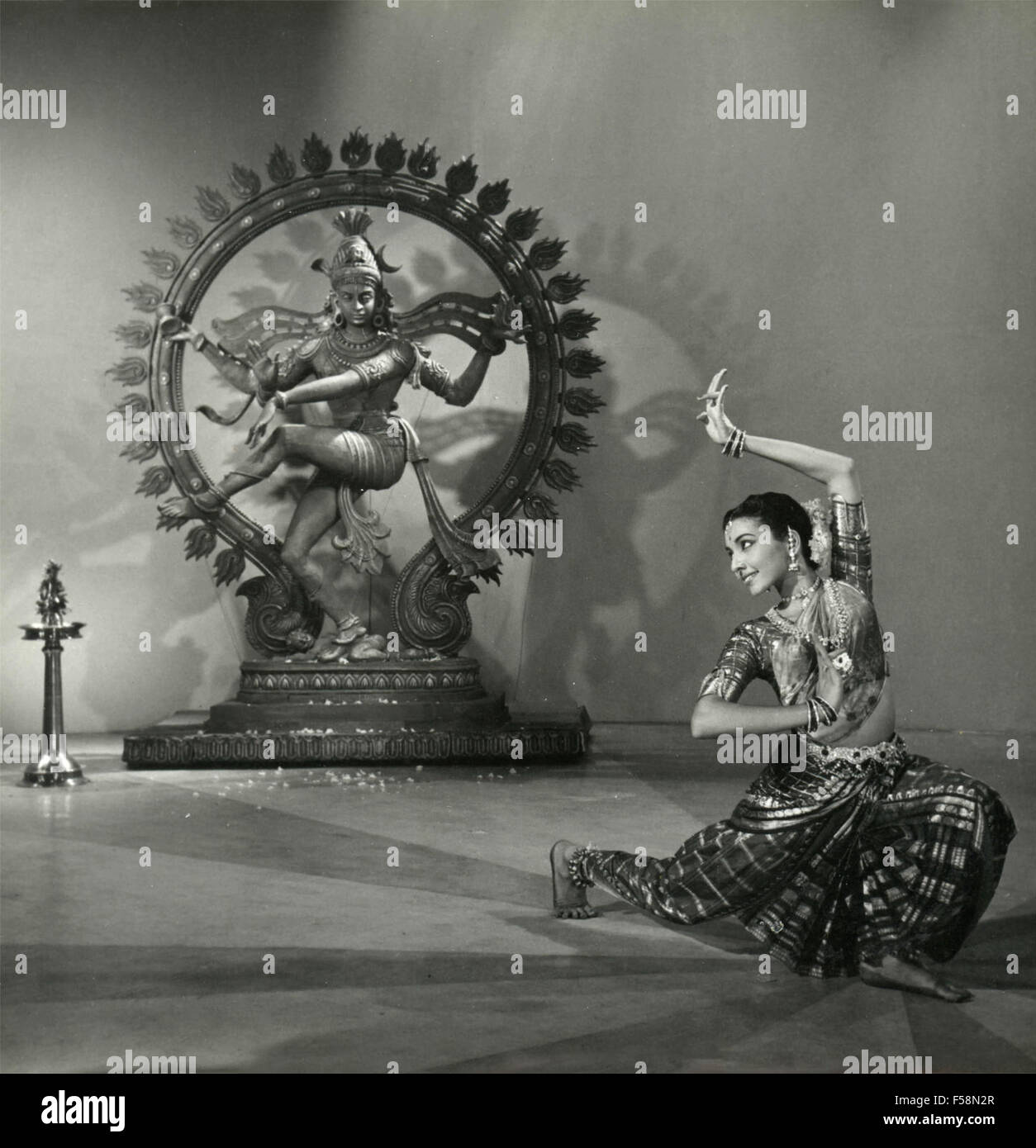 An Indian woman dancing next to the statue of Shiva Nataraja Stock ...