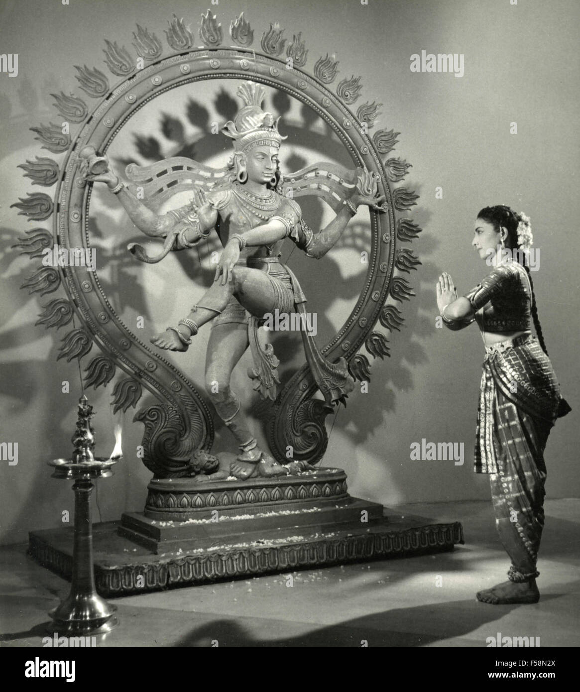 An Indian woman dancing next to the statue of Shiva Nataraja Stock ...