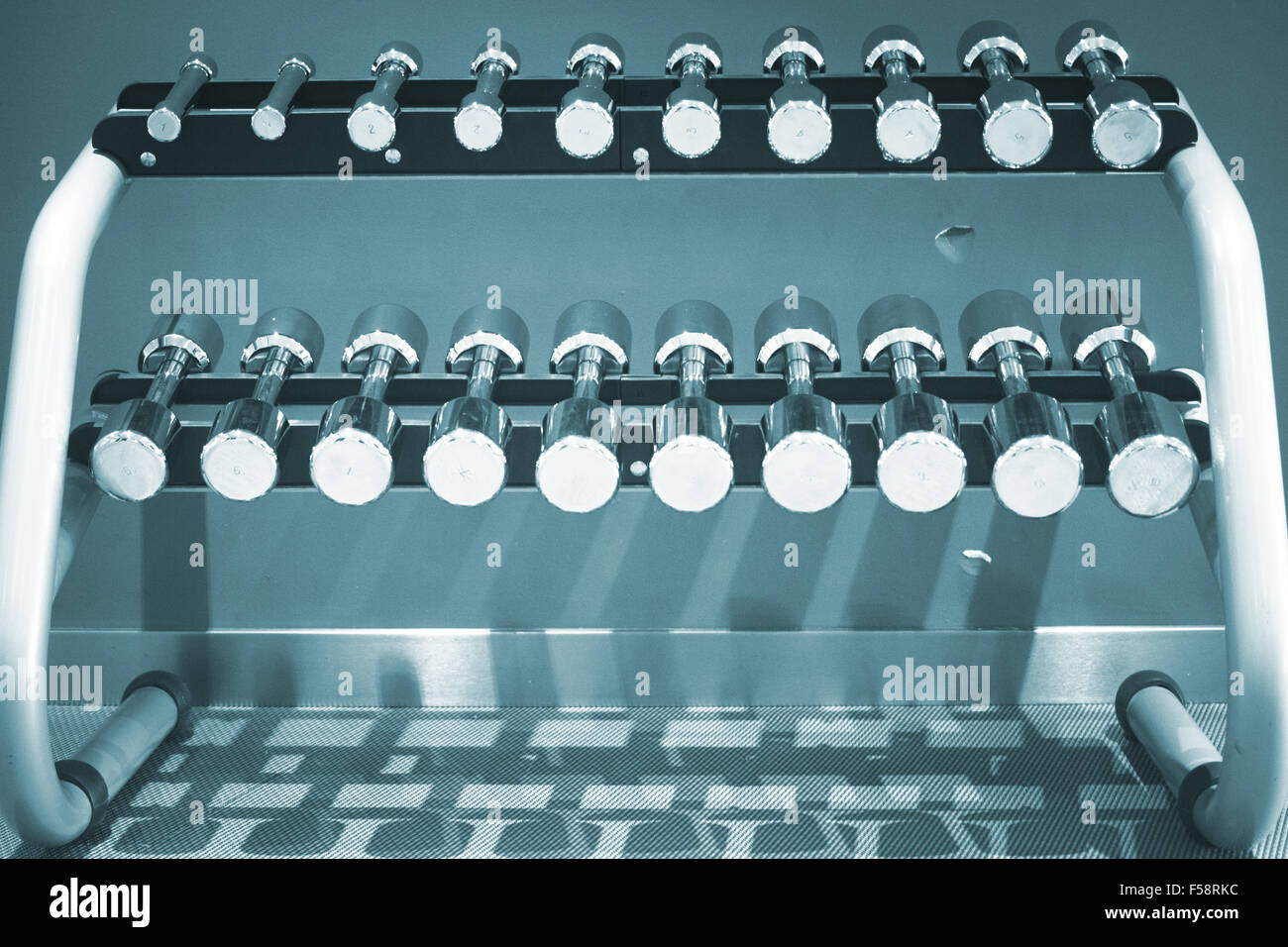 Dumbbell gym metal weights rack in exercise room in sports bodybuilder ...