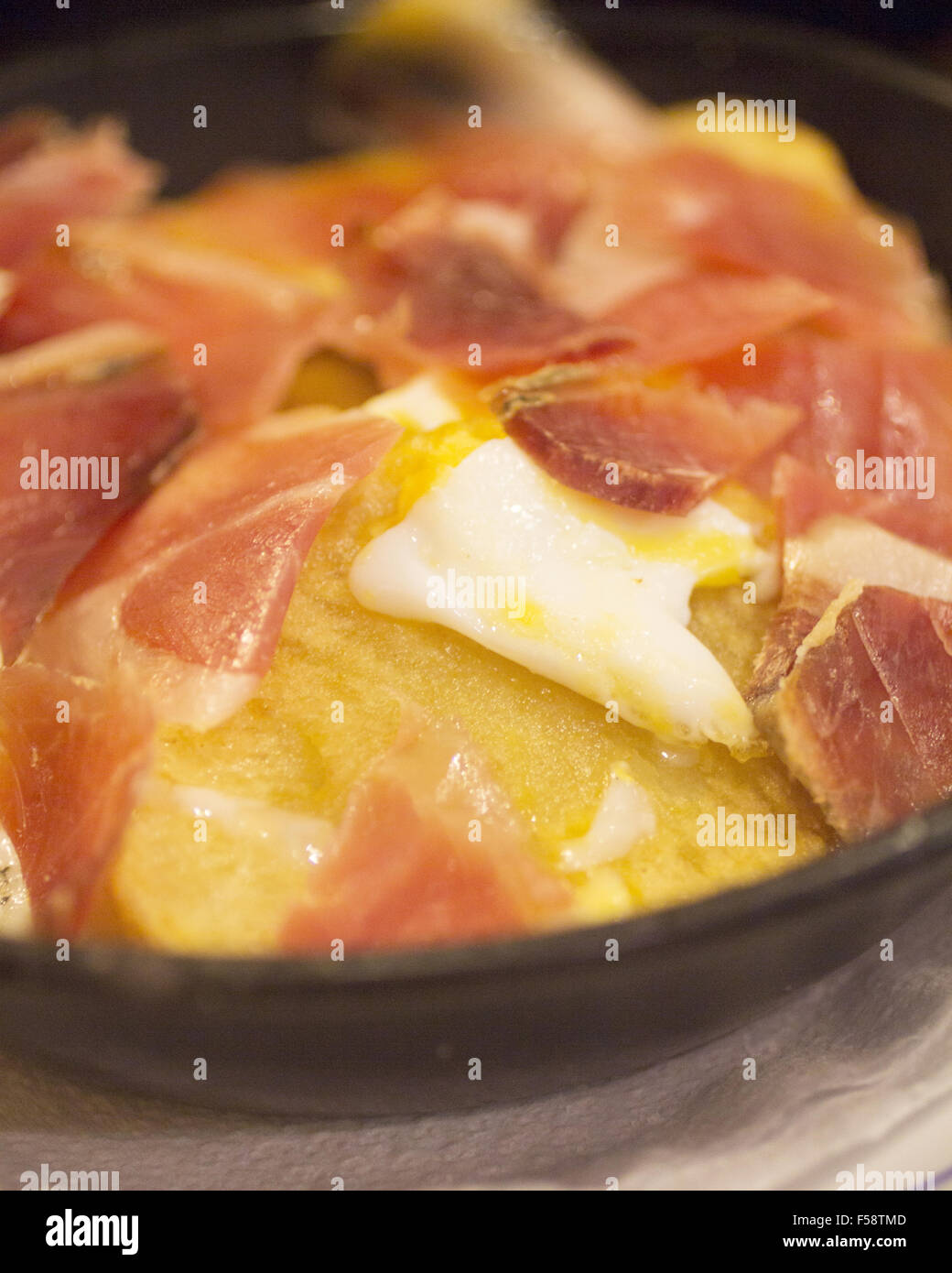 Spanish Serrano sliced ham egg and potato sartenada racion tapas dish ...