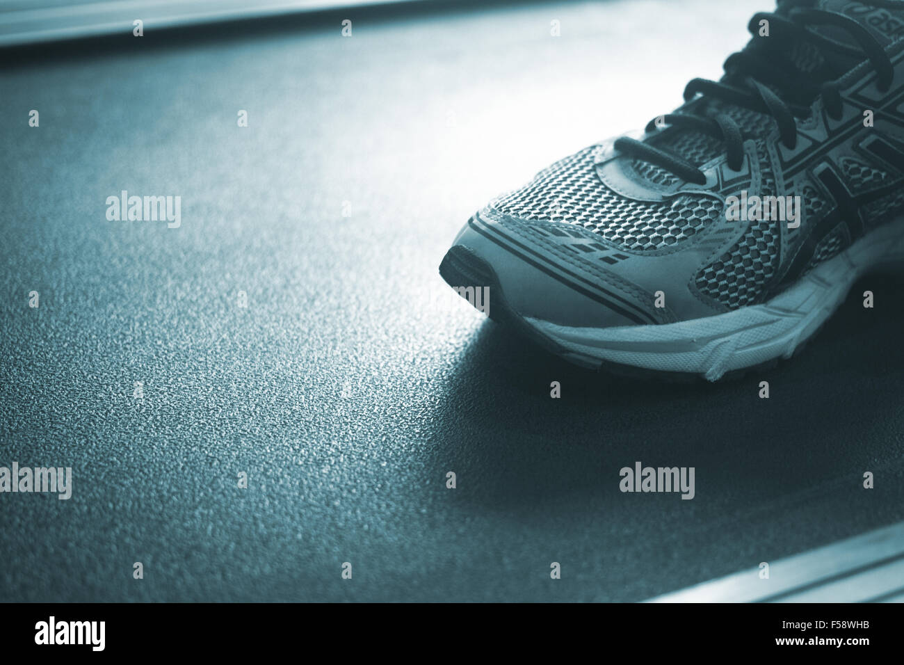 Running machine and runner in sports shoes trainers in exercise room in ...