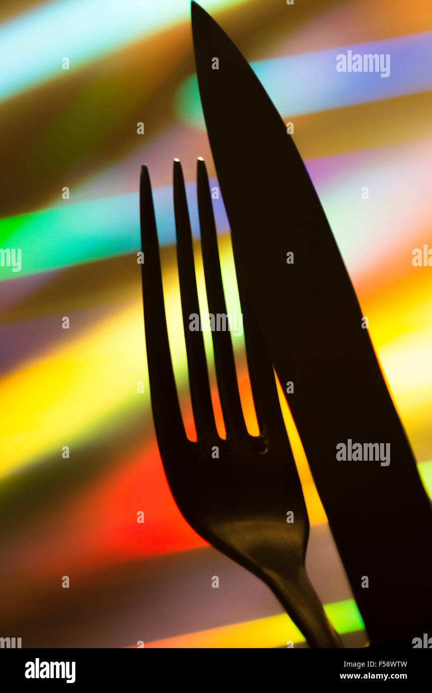 Knife and fork dining symbol silhouette on colorful background photo ...