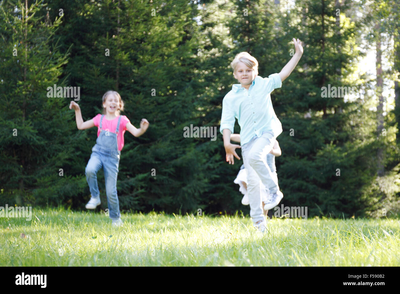 Group of young children running towards camera in park Stock Photo - Alamy