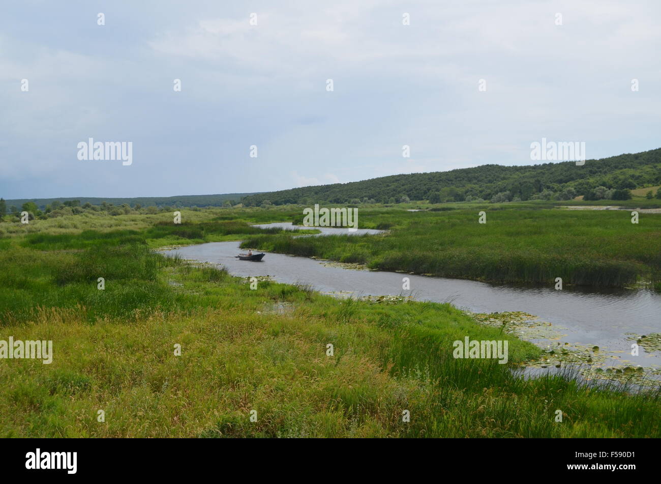 Sailing boat down the stream in the green prairie Stock Photo - Alamy