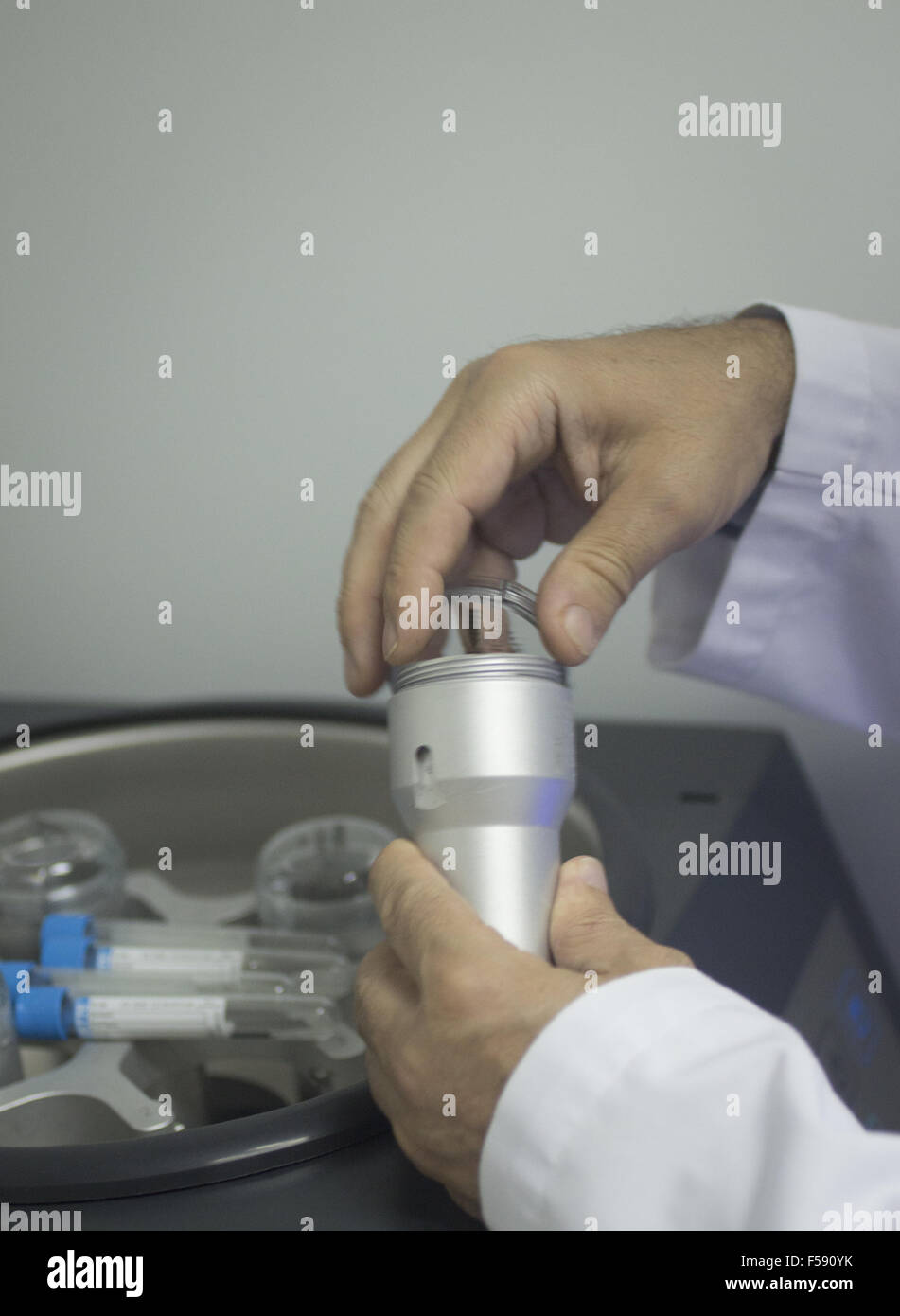 Hands of laboratory technician wearing white lab coat preparing human ...