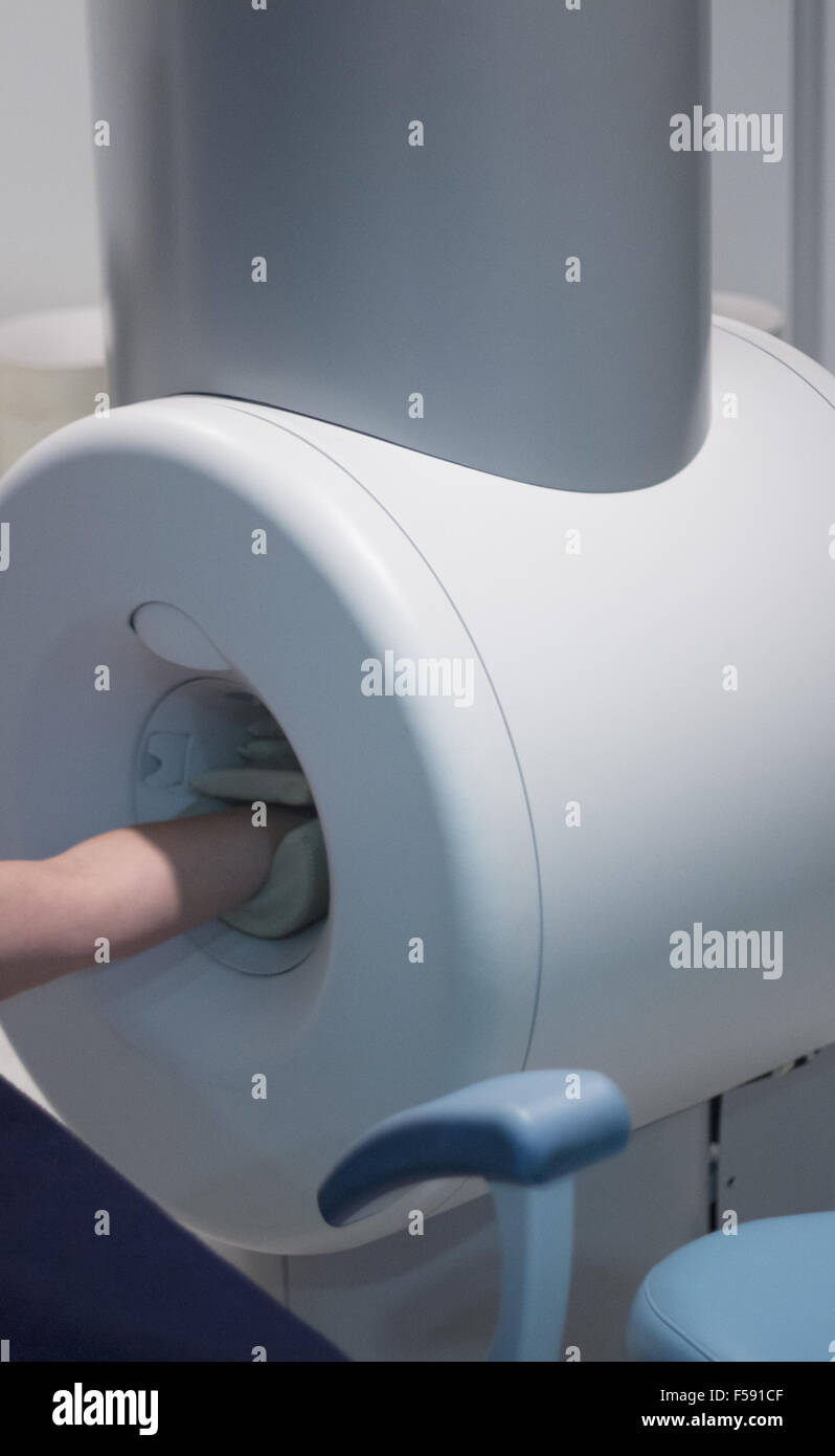 Completely open high field MRI scanner with patient lying with arm ...