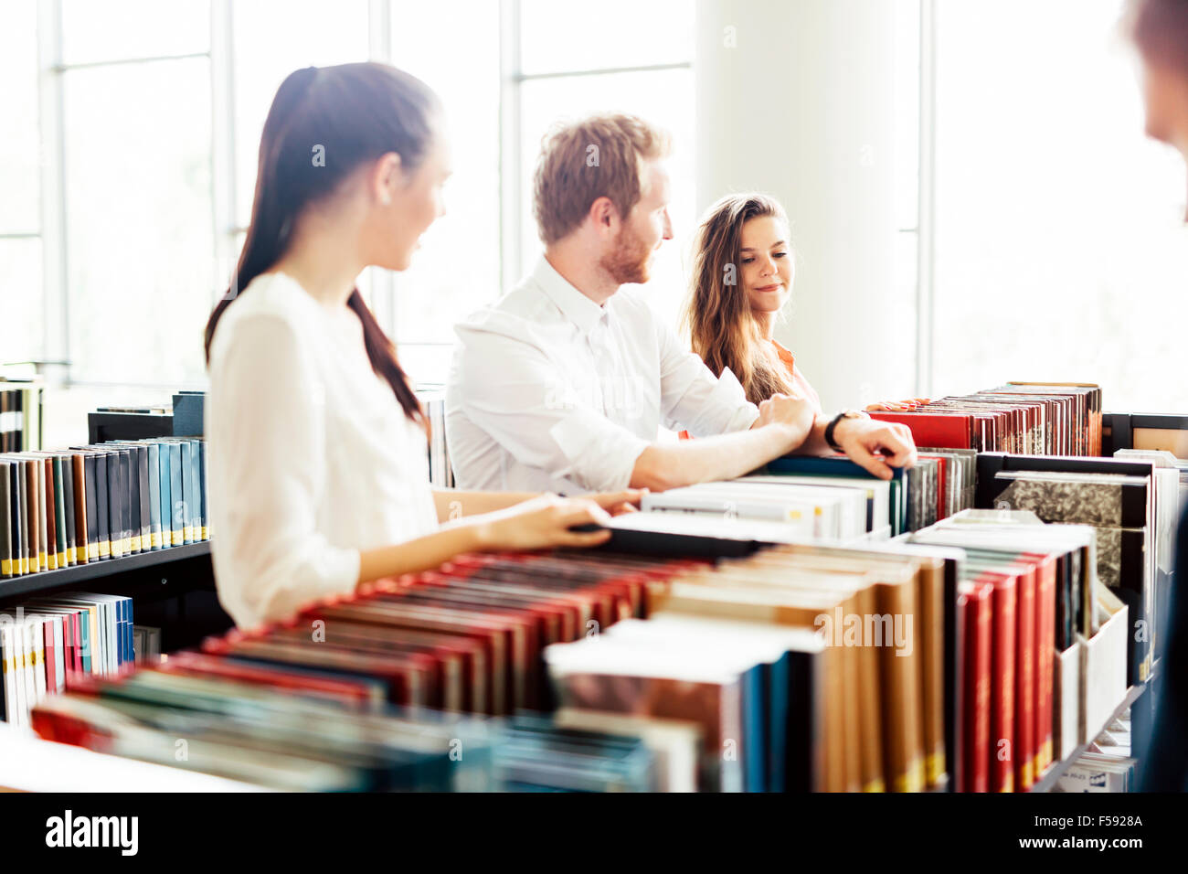 Group of students studying in library and reading books Stock Photo - Alamy