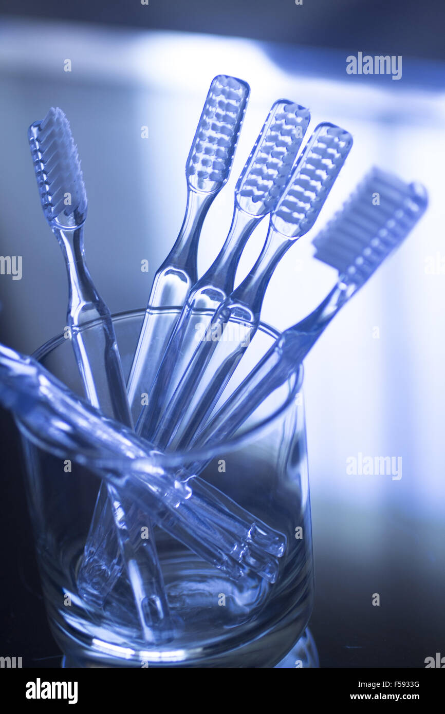 Toothbrushes in glass on glass table dental hygiene plaque control in ...