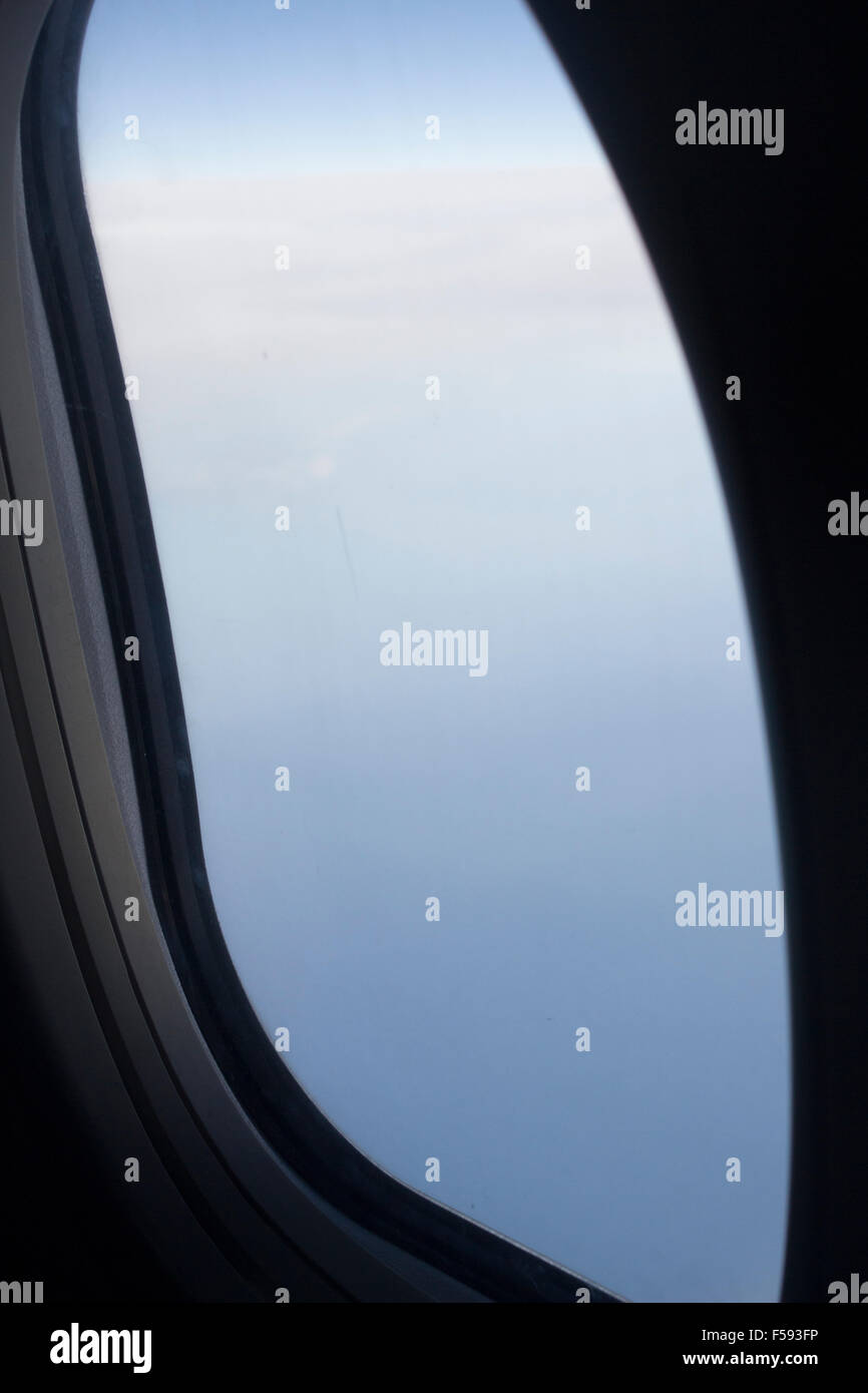 Airplane window looking out seen from inside in flight with sky and ...