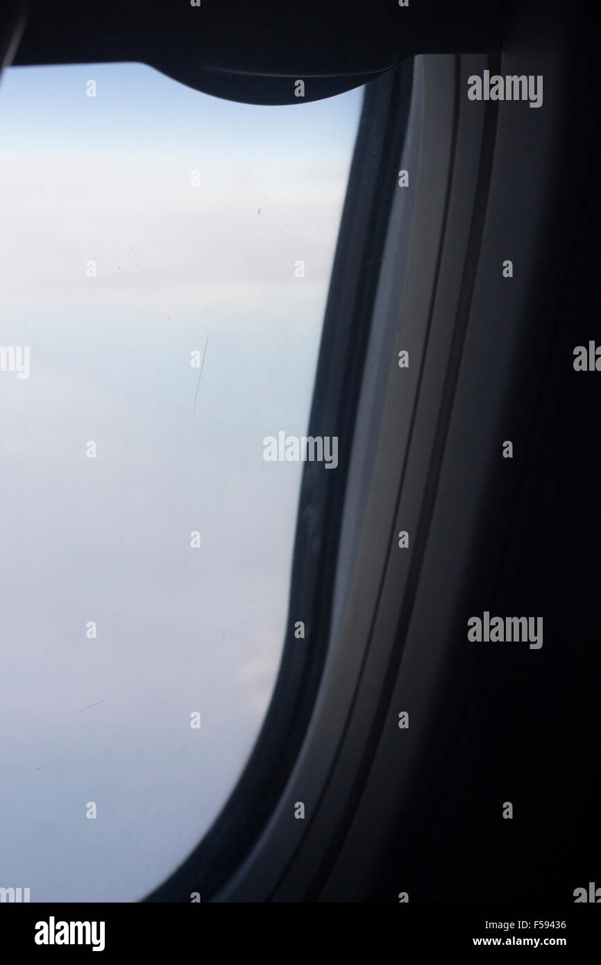 Airplane window looking out seen from inside in flight with sky and ...
