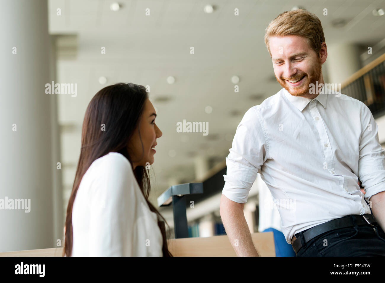 A group of academics studying in the library and conversing in a ...