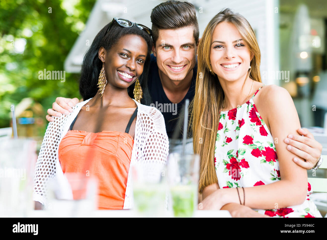 Happy young friends smiling outdoors being close to each other on a ...
