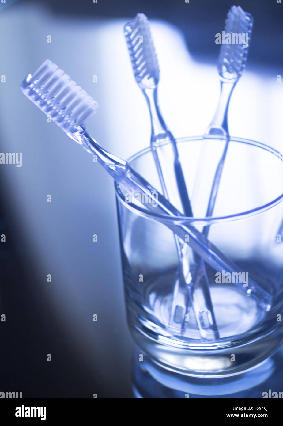 Toothbrushes in glass on glass table dental hygiene plaque control in ...