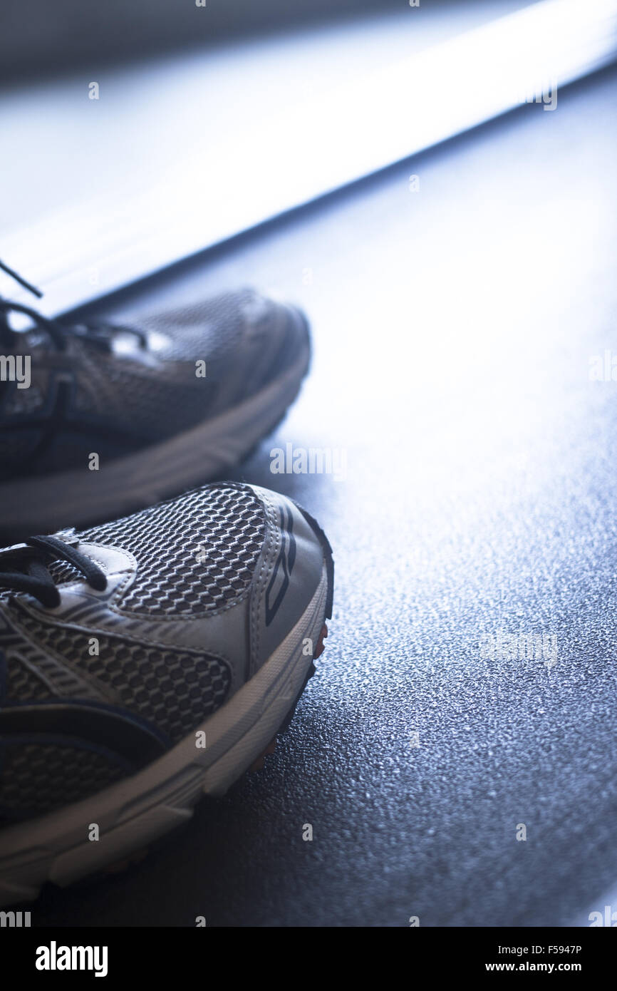 Running machine and runner in sports shoes trainers in exercise room in ...
