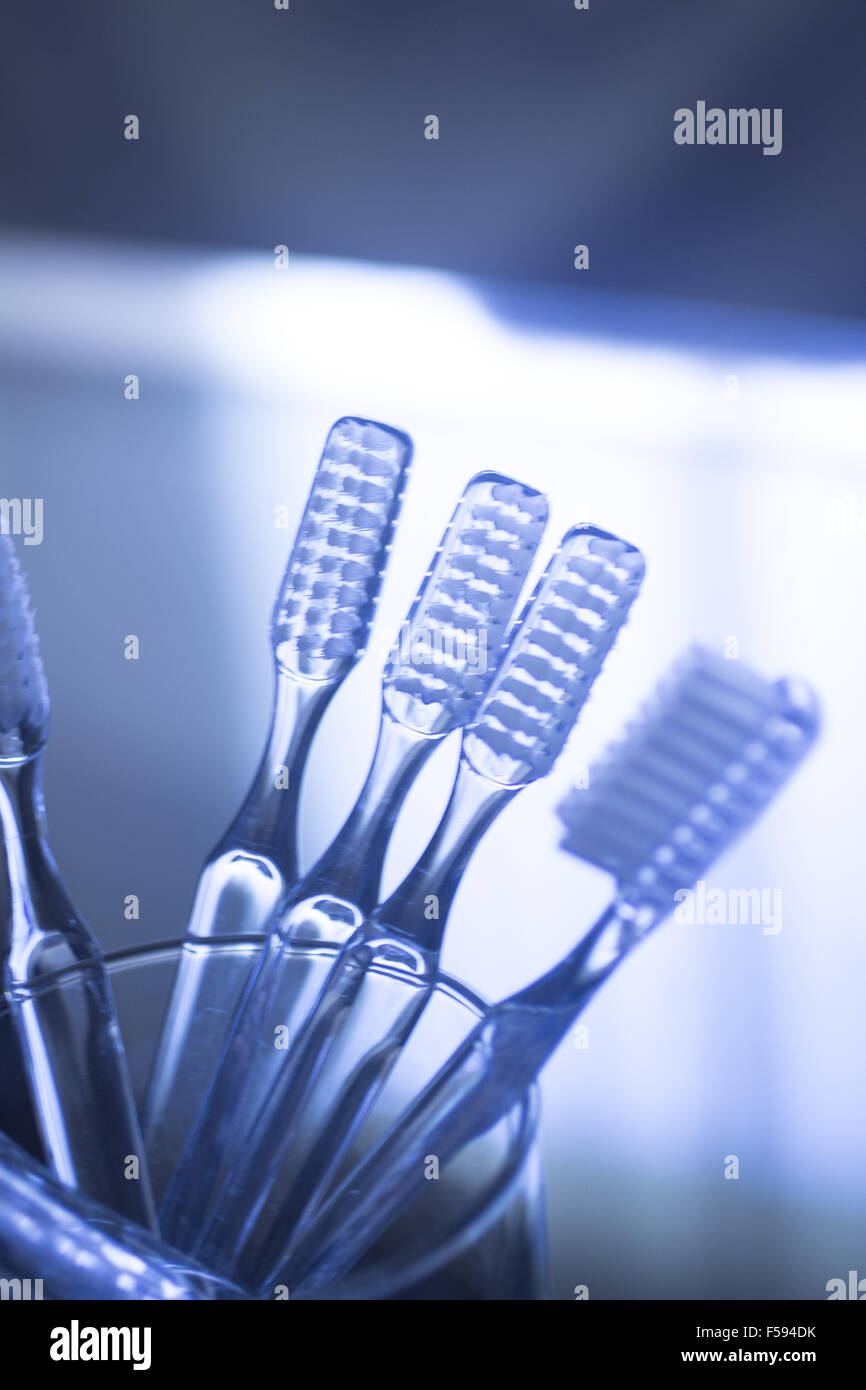 Toothbrushes in glass on glass table dental hygiene plaque control in ...