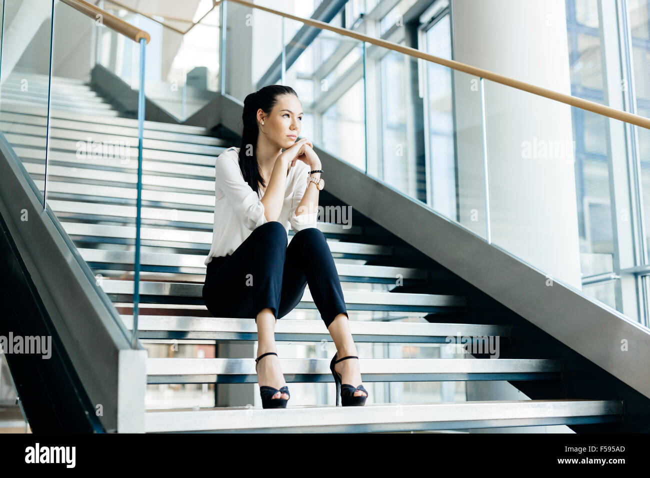 Businesswoman sitting on stairs and thinking. Fashion style photo Stock ...