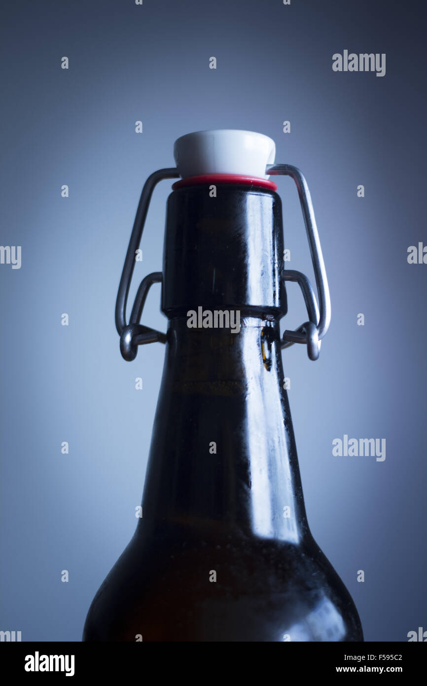Lager beer bottle with clamp top studio isolated close-up on plain blue ...