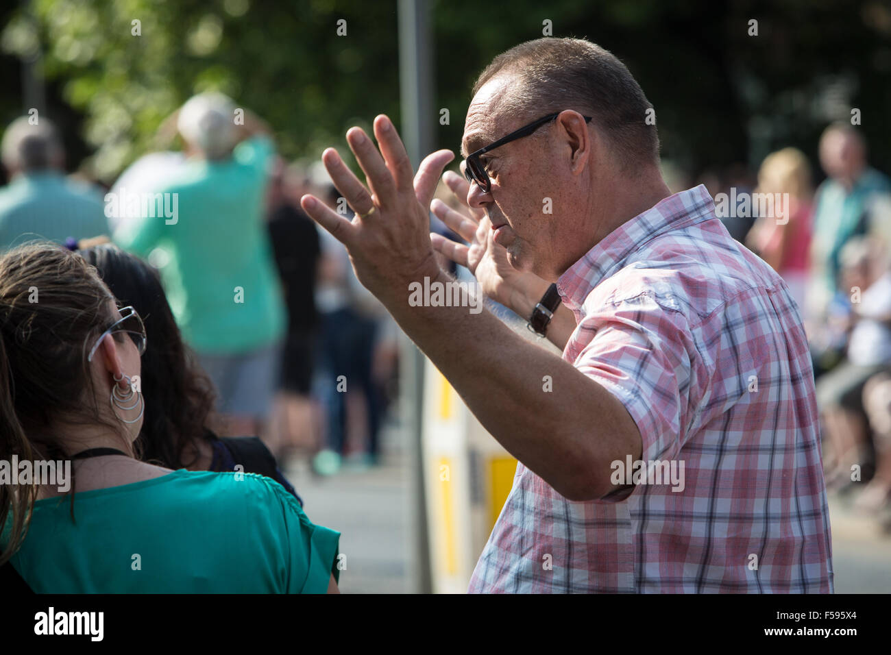 man holds his arms aloft appearing to be exasperated whilst talking to ...
