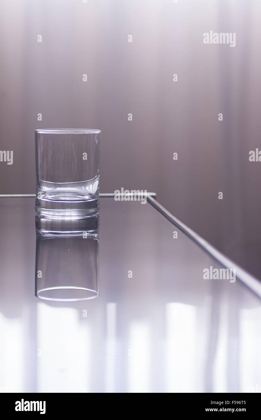 Glass of water on table in window light effect photo Stock Photo - Alamy