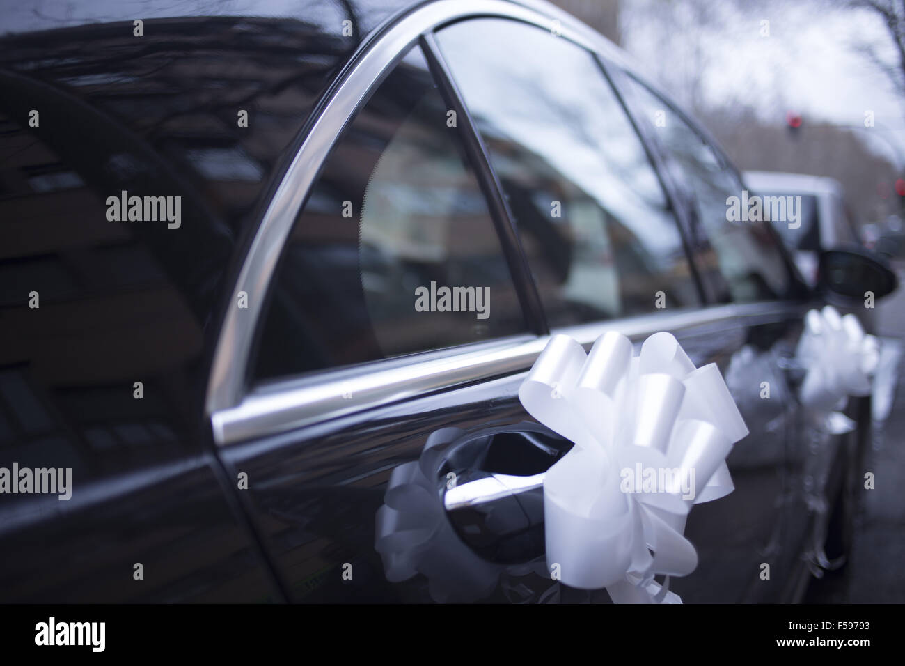 Bridal white flower bouquet on wedding car door with focus on ...