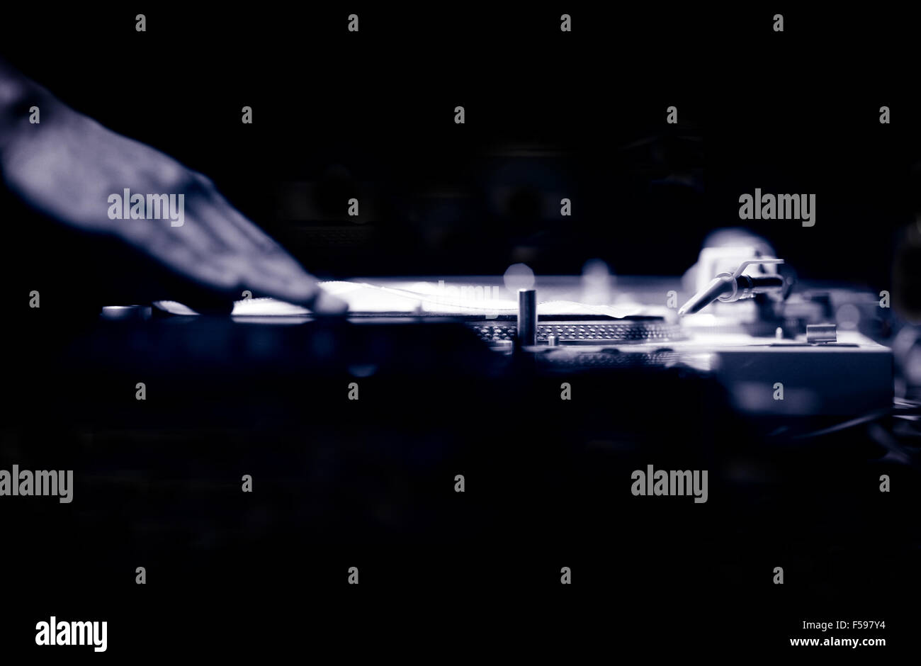 DJ deejay hand on record turntable in nightclub dscoteque mixing music ...