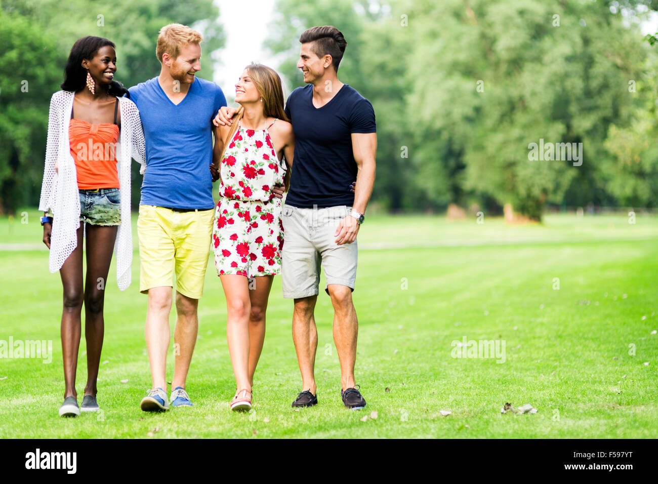 Cheerful friends walking in nature outdoors and having a good time ...