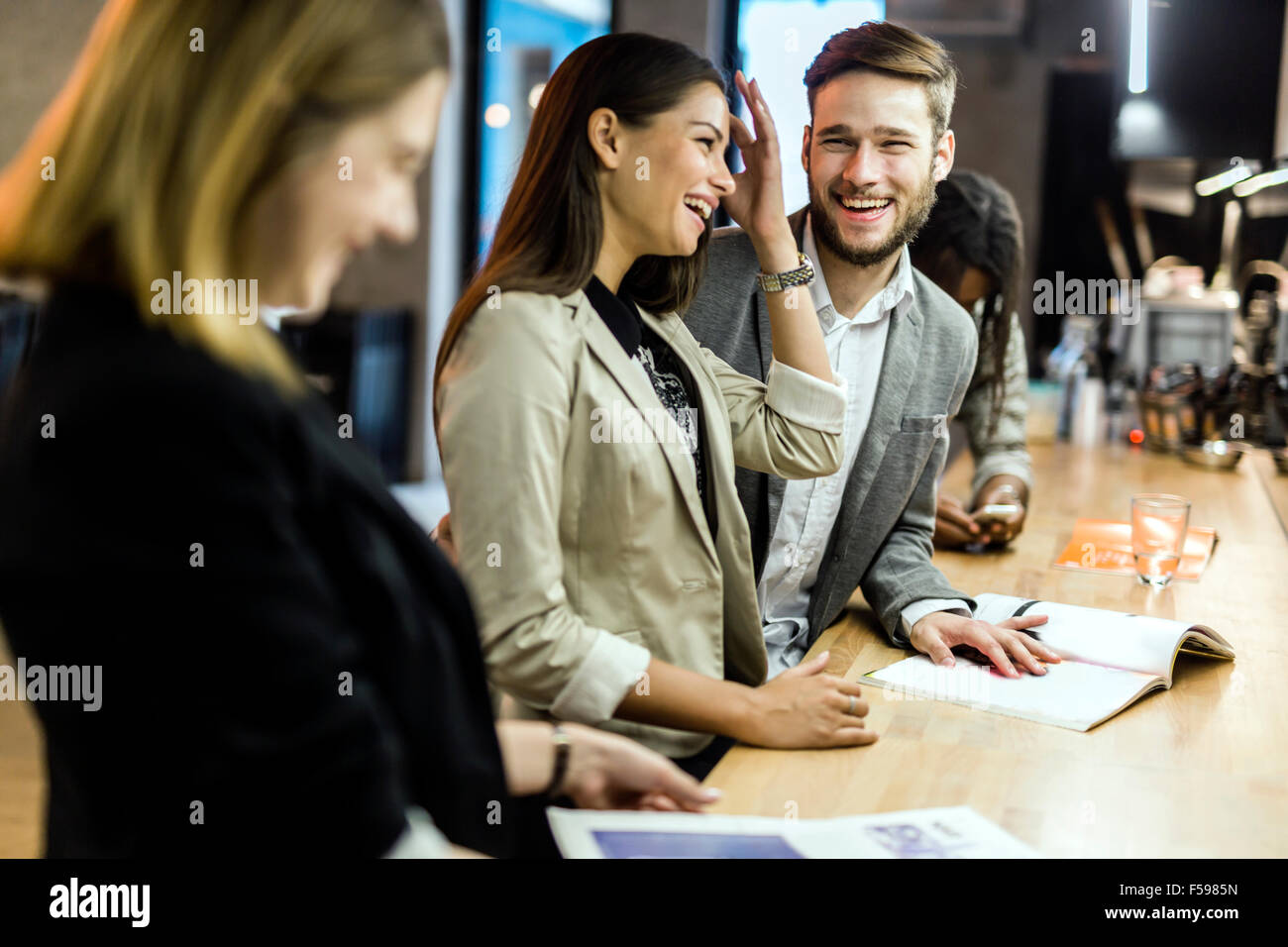 Friends at the counter of a bar after work having fun and smiling Stock ...