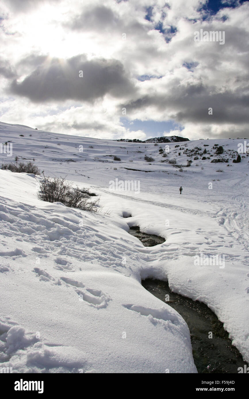 Hicker walking by river wading through the snowy landscape, province of ...