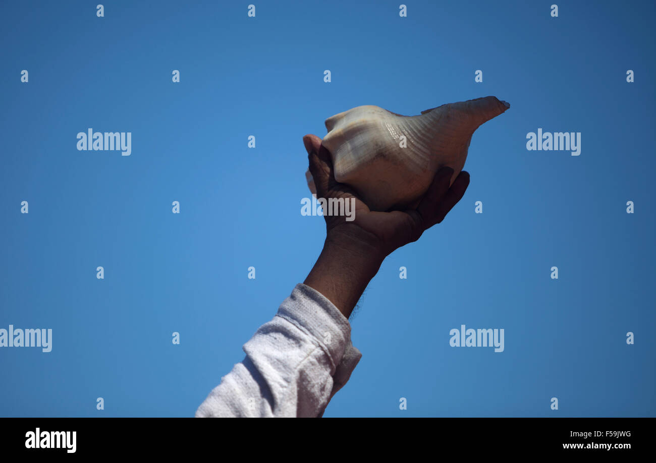 A Mayan shaman or h-mem holding a seashell blesses the opening of the ...