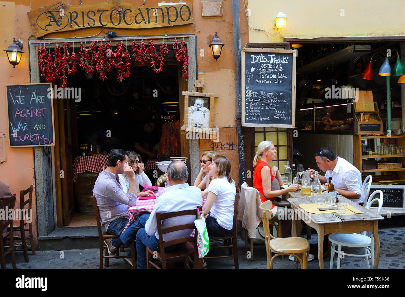 Diners enjoying eating outdoors at a small restaurant in Trastevere ...